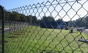 Elo de corrente que cerca a parede de limite que cerca para o campo de esportes do lazer